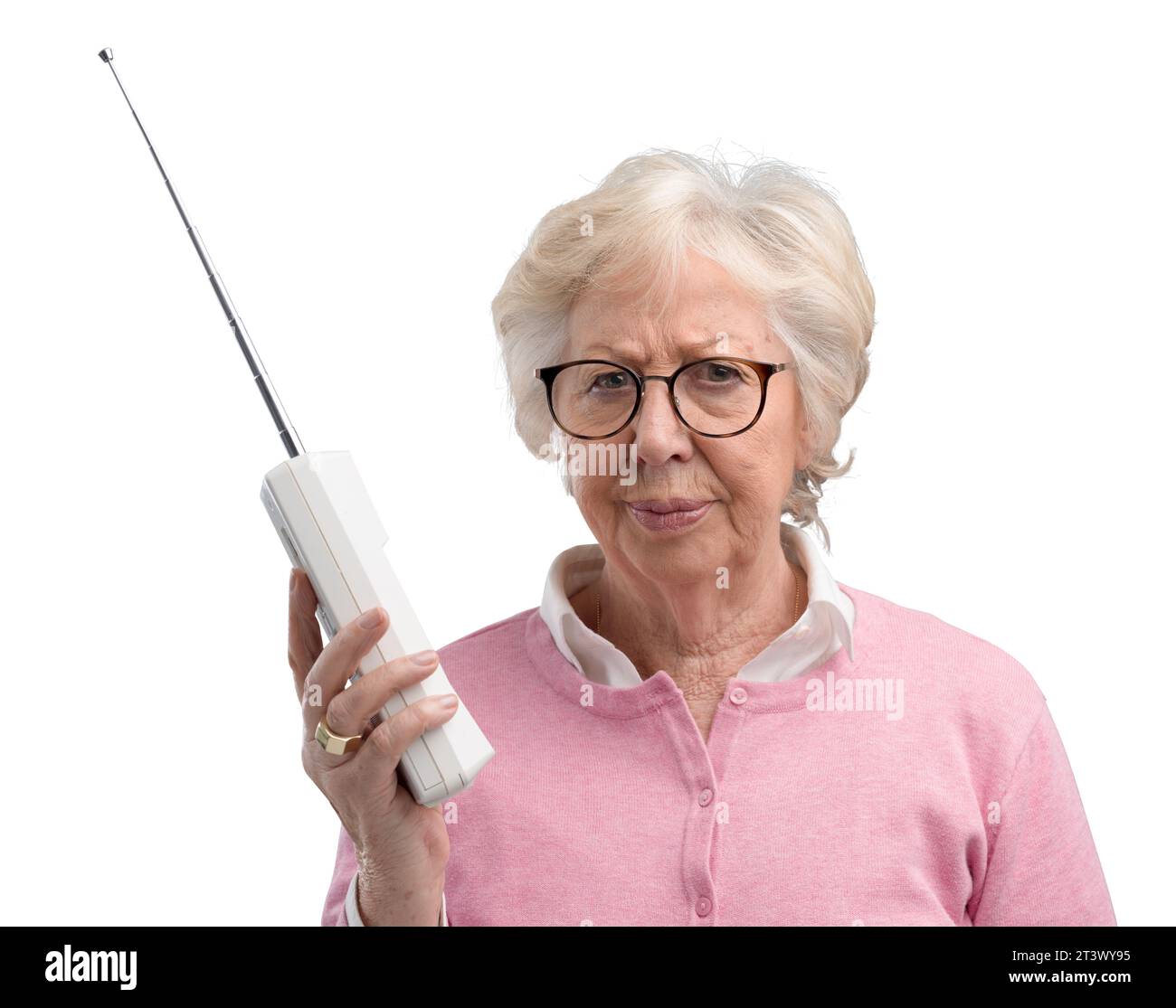 Frustrated senior woman using an old cordless telephone, she is looking ...