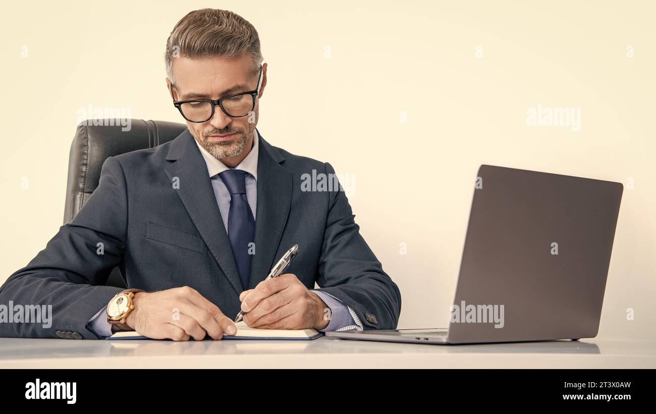 mature businessman sitting in business office taking notes Stock Photo ...