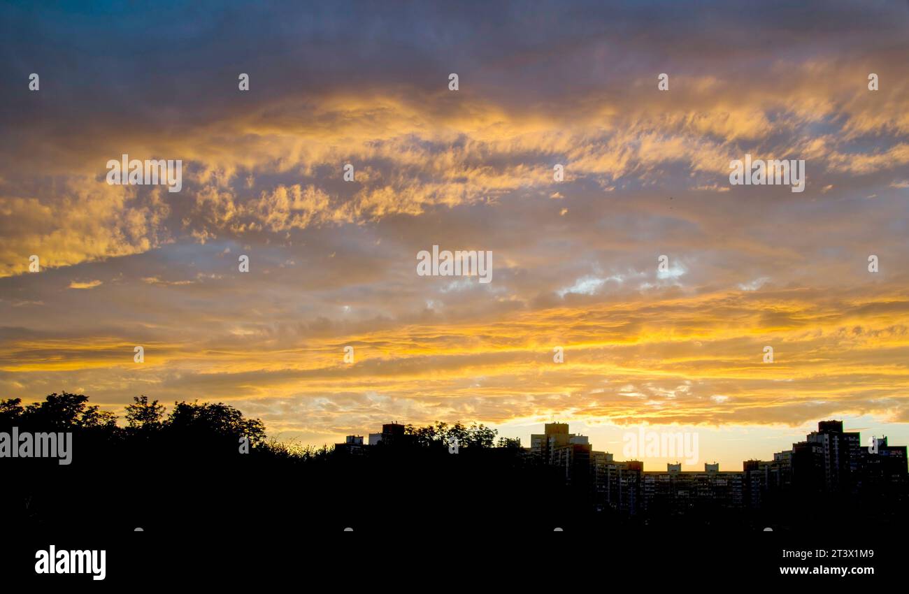 Stormy sky in fire of sunset and black outline cityscape. Burning ...