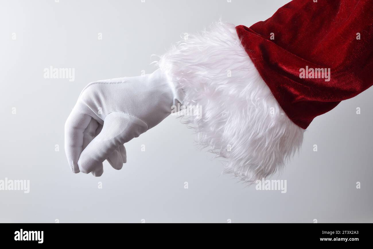 Santa claus hand with white glove and red traditional costume making ...