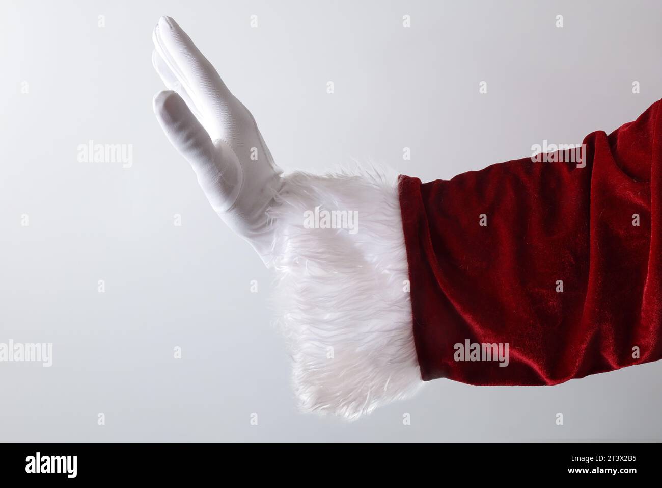 Santa claus hand with white glove and red traditional costume making ...