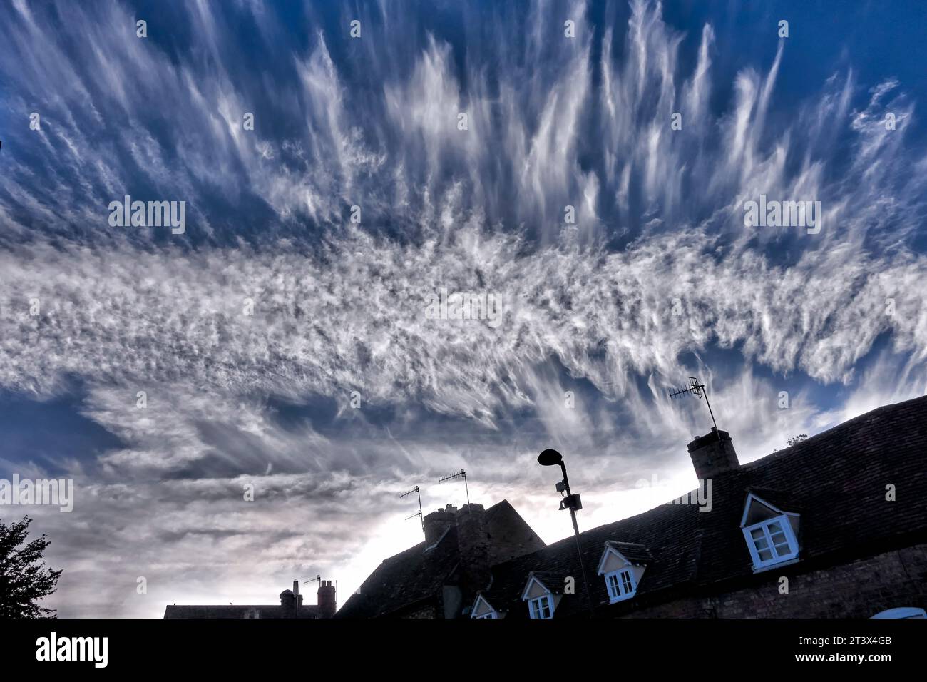 Cirrus clouds also known as mares tails, with houses below. England UK ...