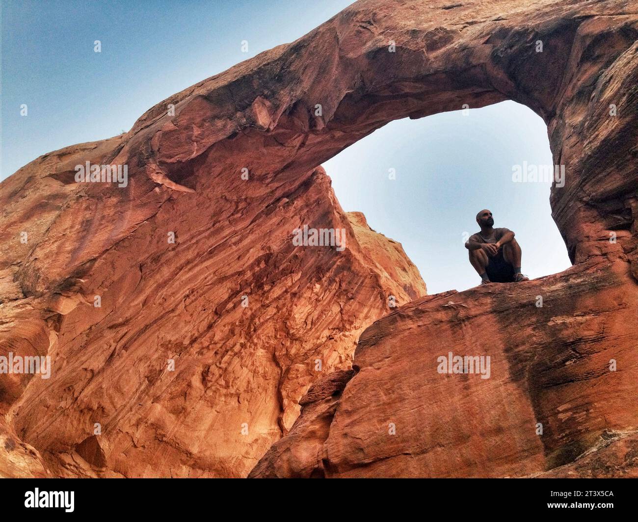 Whit Richardson sits beneath Funnel Arch Moab Utah Stock Photo - Alamy