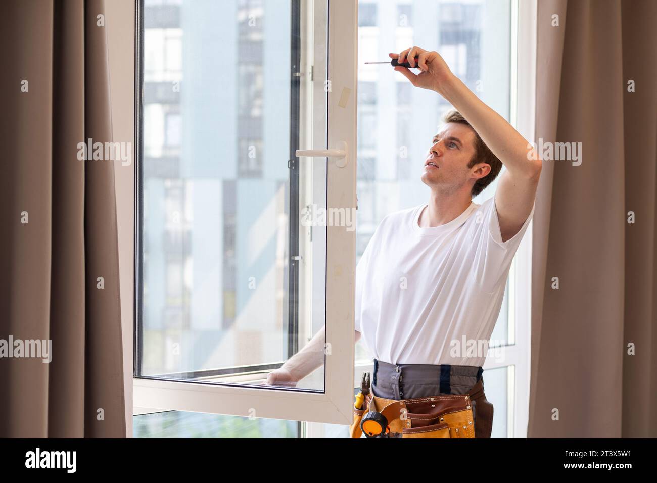 Construction worker installing window in house Stock Photo - Alamy