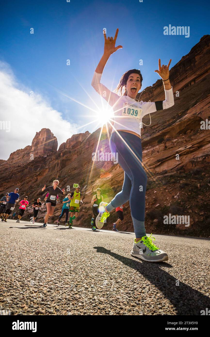 Low angle backlit view of a woman runner passing while throwing up her ...