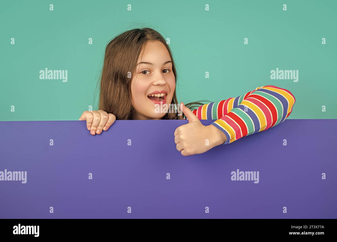 happy kid behind blank blue paper with copy space for advertisement ...