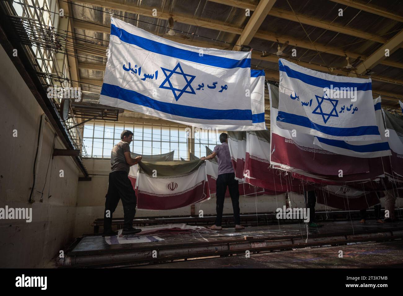 Chomein, Iran. 27th Oct, 2023. Employees at a factory hang flags after ...