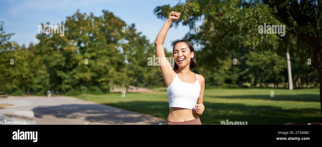 Hooray, victory. Smiling asian girl triumphing, celebrating achievement ...