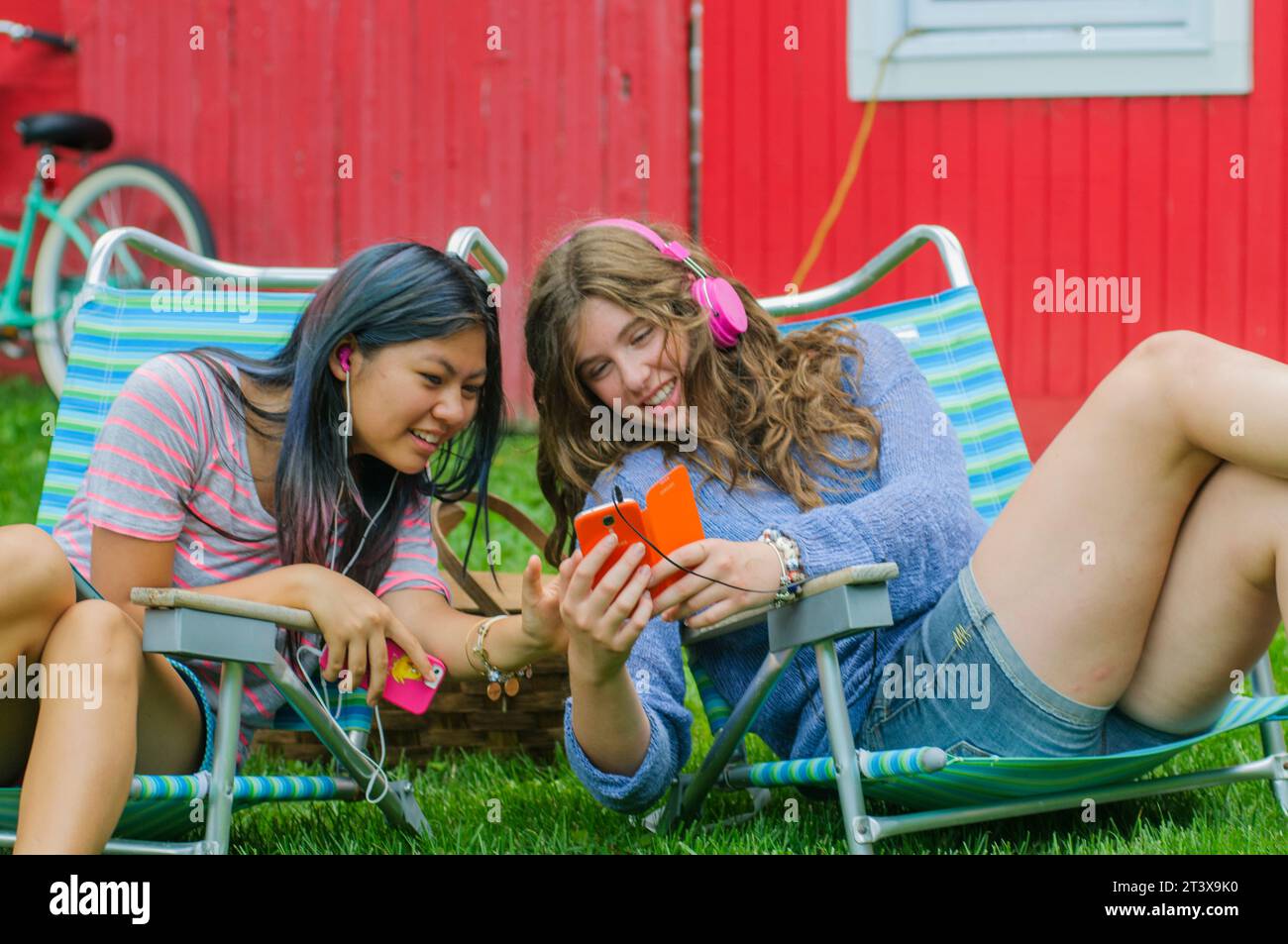 Teen girls together on phones having fun Stock Photo - Alamy