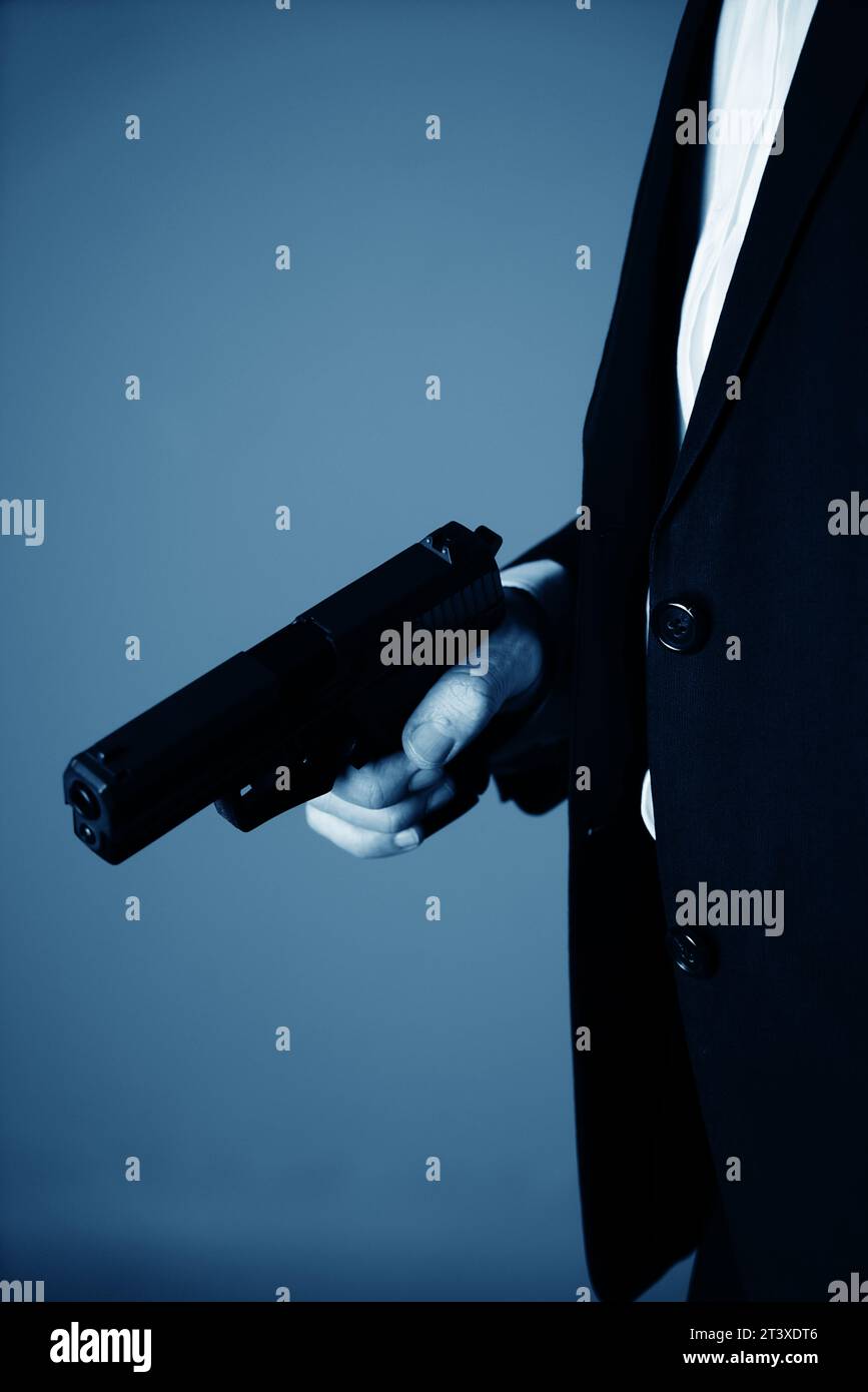 Retro secret agent with pistol revolver gun in hand in vintage crime ...