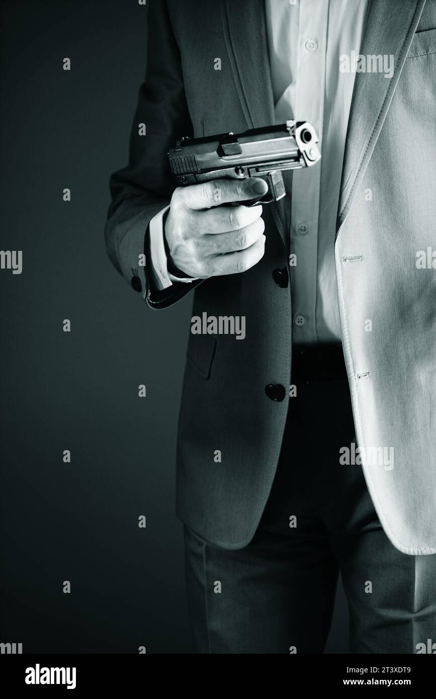 Retro secret agent with pistol revolver gun in hand in vintage crime ...