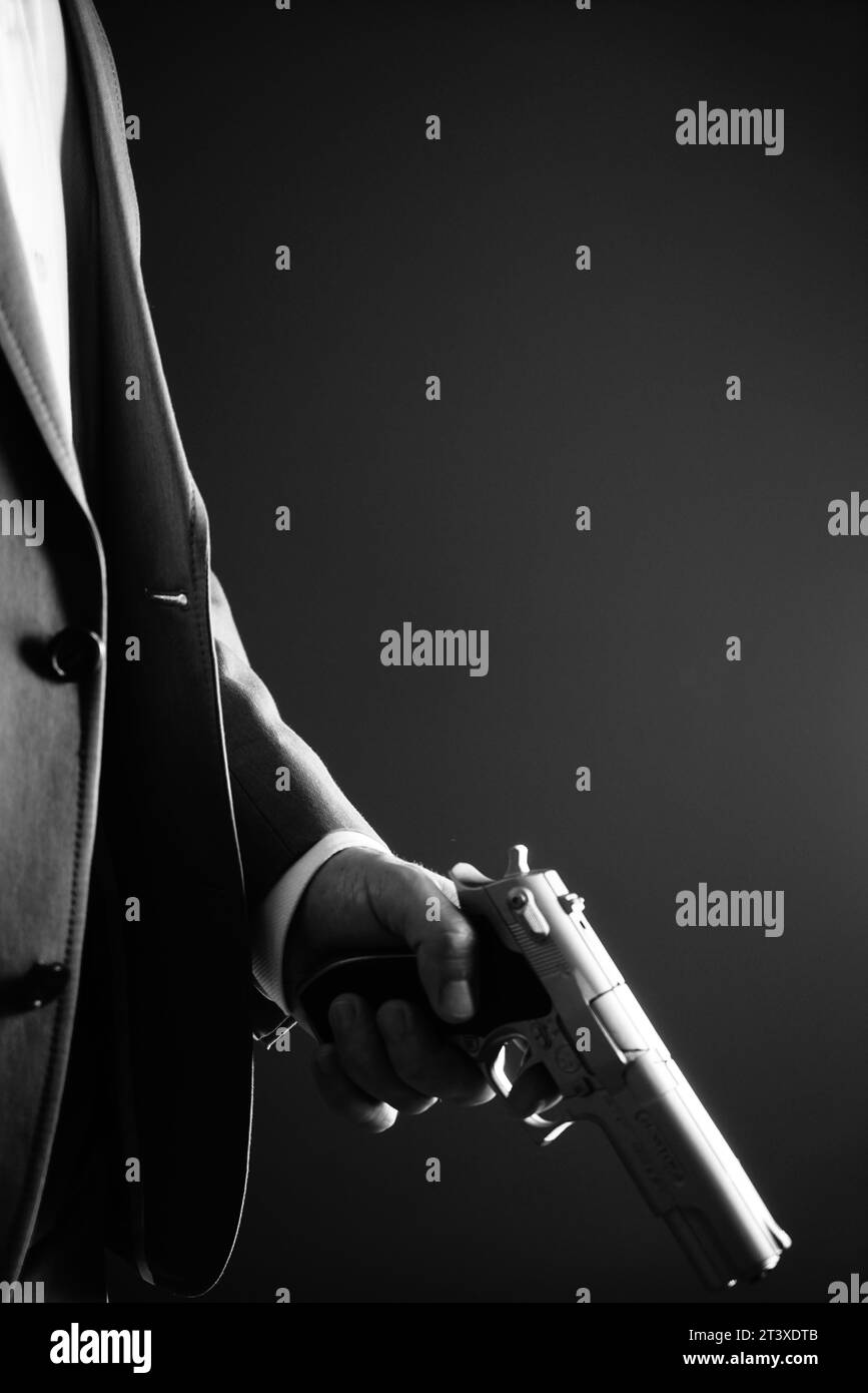 Retro secret agent with pistol revolver gun in hand in vintage crime ...