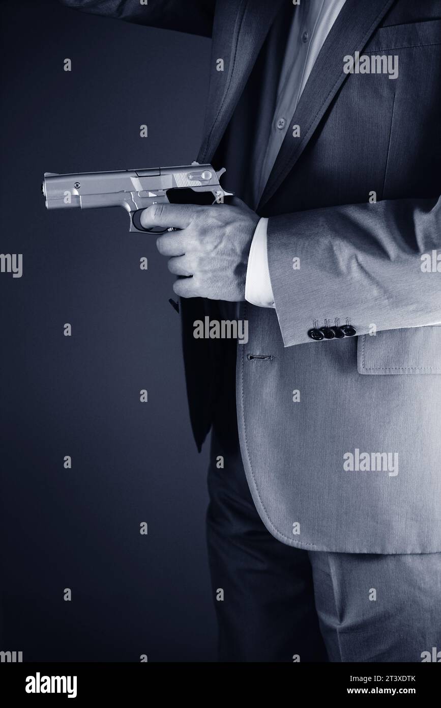 Retro secret agent with pistol revolver gun in hand in vintage crime ...
