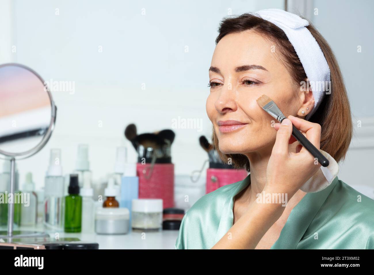 Beautician put makeup prime foundation cream on woman's face Stock ...