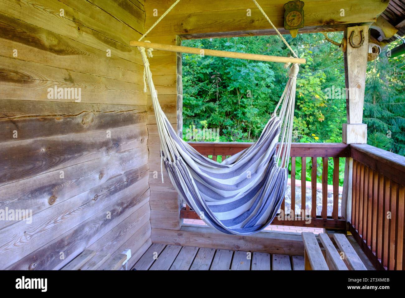 A hammock in front of the building. Rest in nature, in a shady place ...