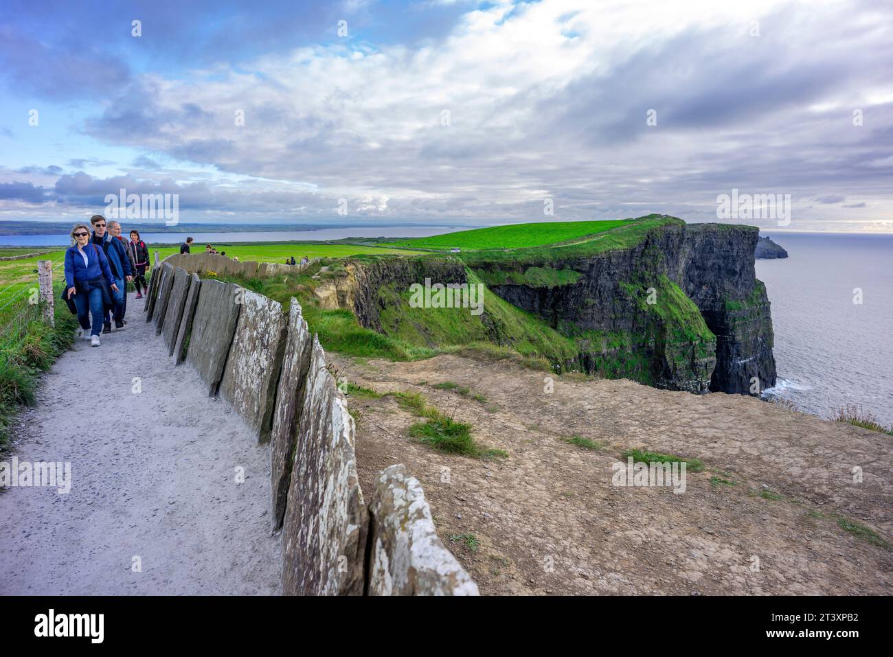 hiker between traditional stone fence, Cliffs of Moher, The Burren ...