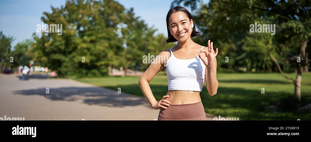Sport people. Happy asian girl, sportswoman showing okay sign and ...