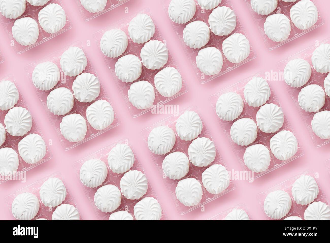 Packs of soft white vanilla zephyr on light pink table. Banner with ...