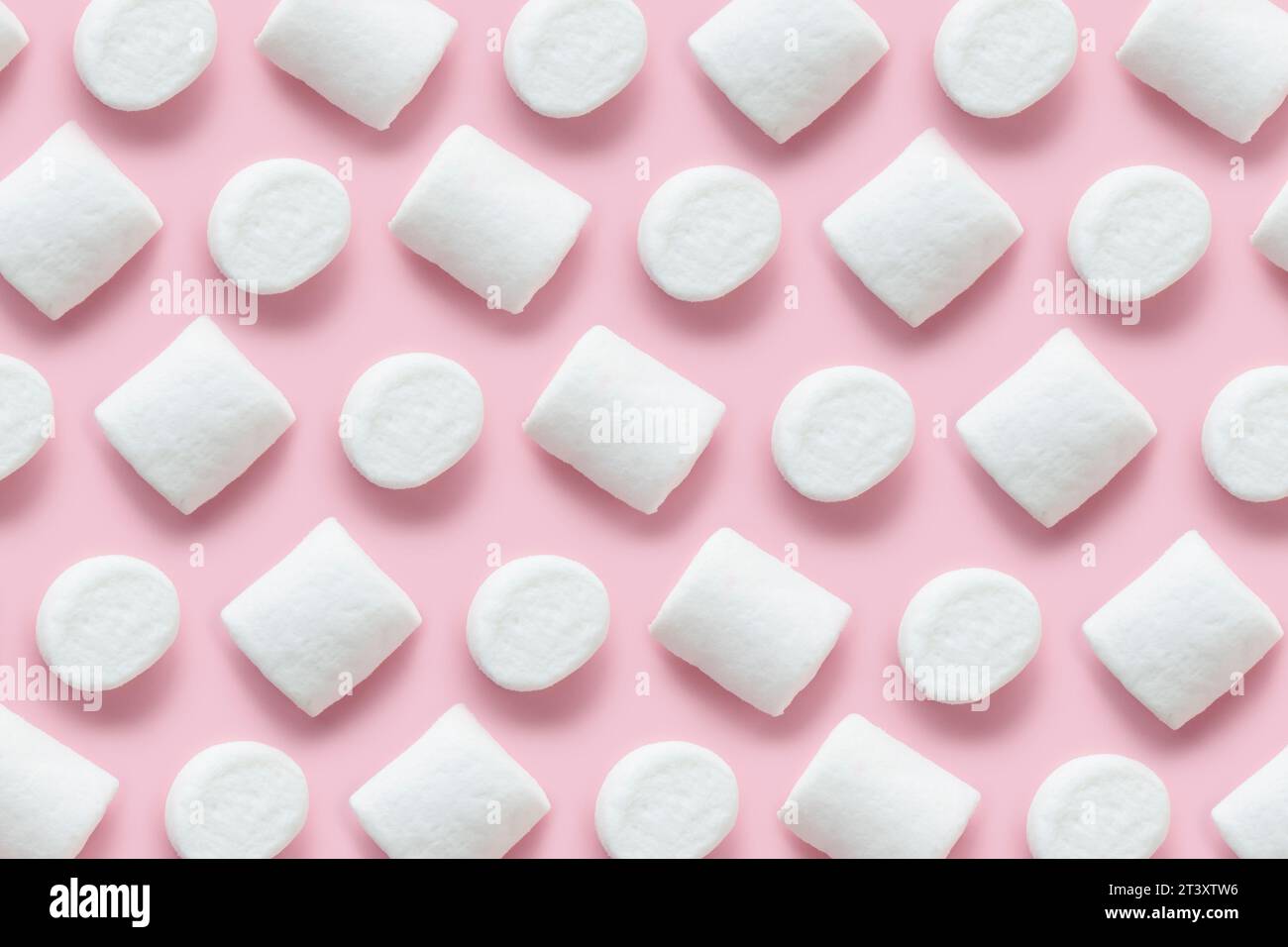 Rows of white marshmallows pattern on light pink table background in ...