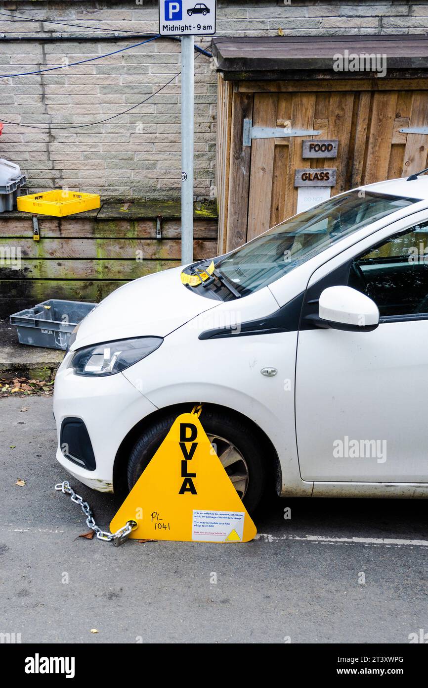 A car with a clamp on its front wheel parked in Newquay in Cornwall in ...
