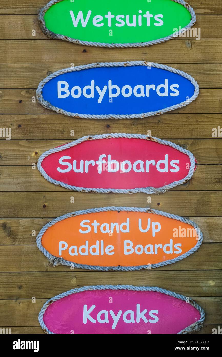Colourful signs advertising surfing equipment on a board at Towan Beach ...