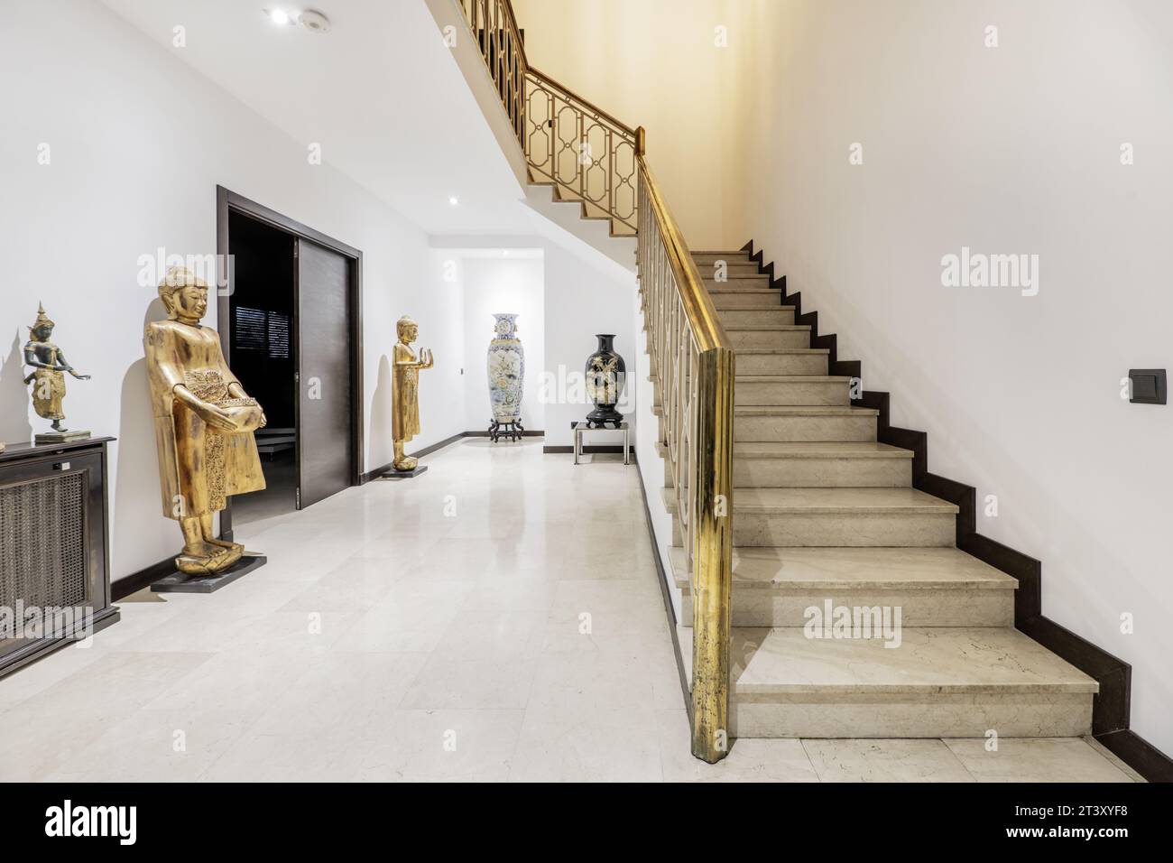 Light marble stairs with gilded metal railing and large decorative ...