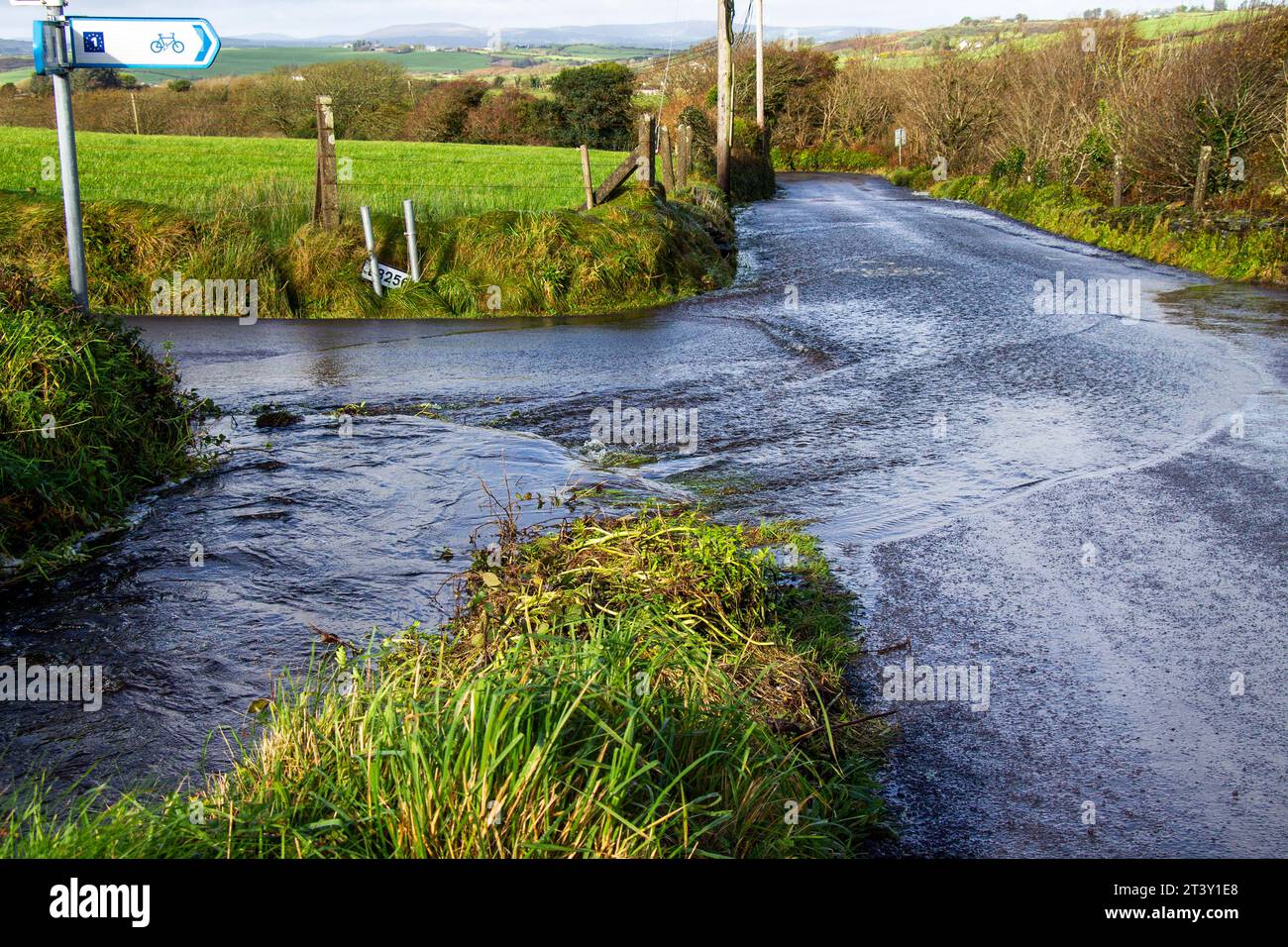 Overflowing stream flooding road Stock Photo - Alamy