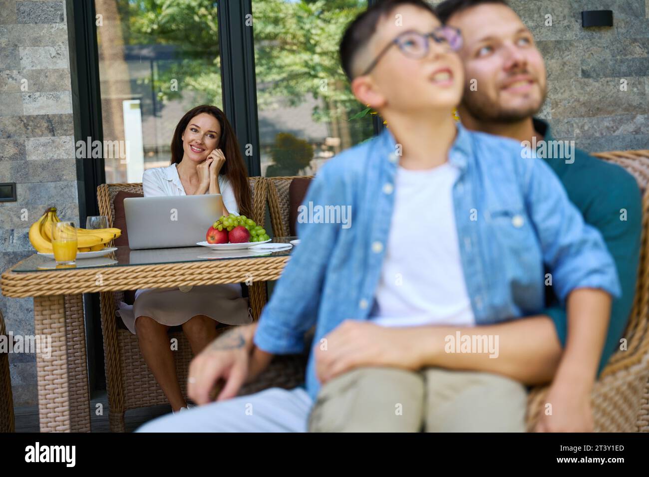 Boy sits on his fathers lap Stock Photo - Alamy