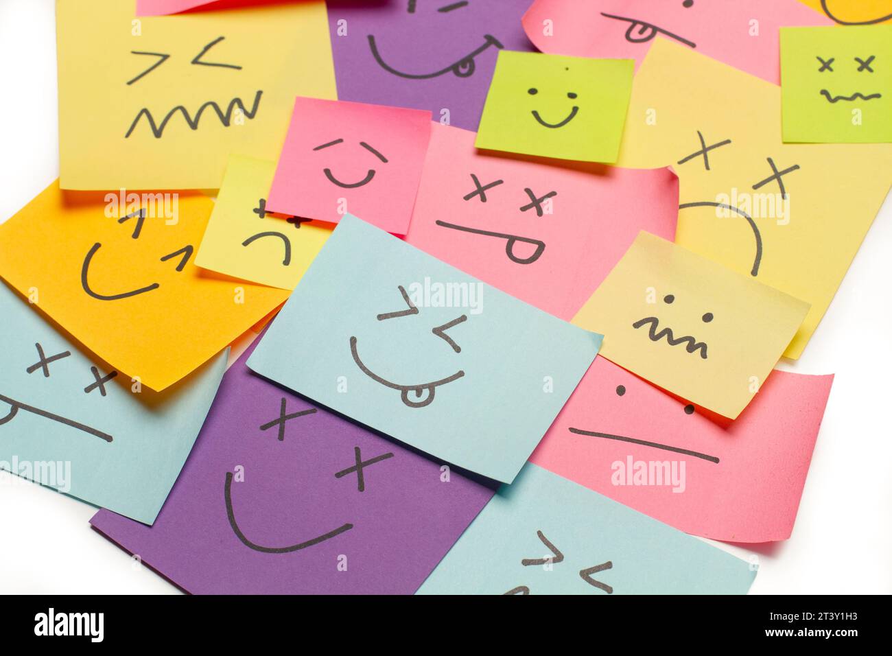 Colored paper notes with drawings of different face emotions on a white ...