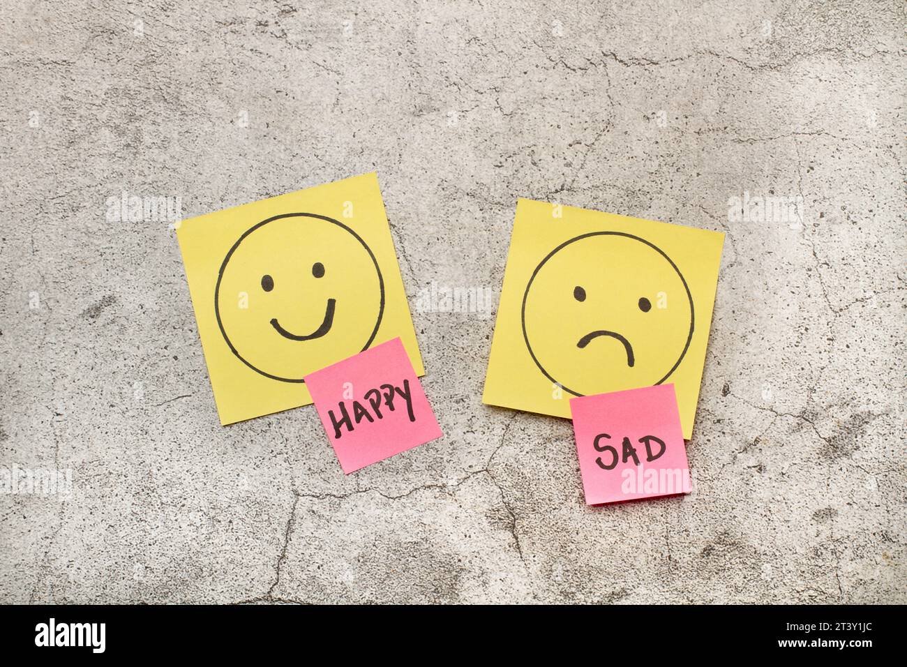 Colored paper notes with sad and happy drawing faces and single words ...