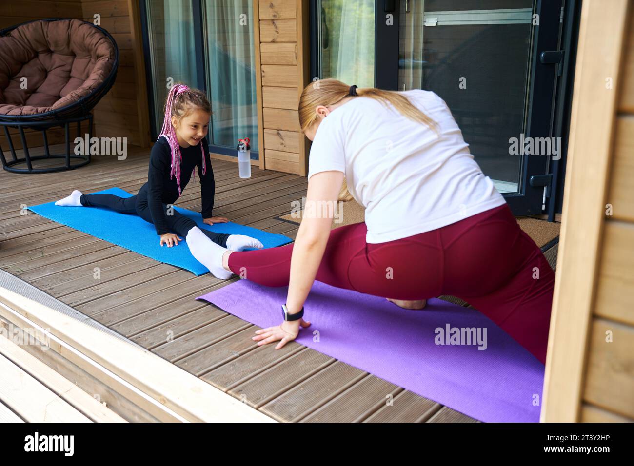Persistent mother stretching her legs trying to do the split Stock ...
