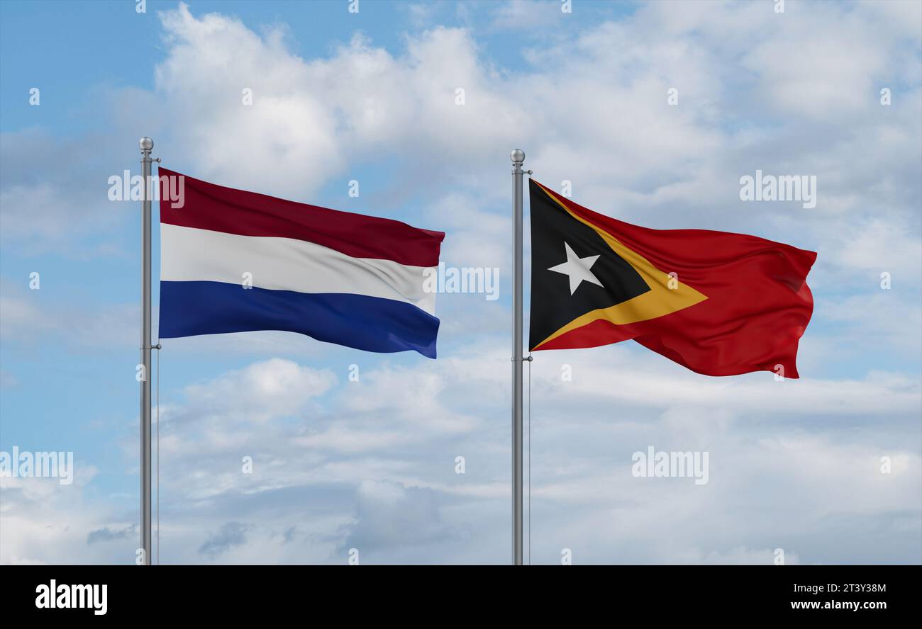 East Timor and Netherlands flags waving together in the wind on blue ...