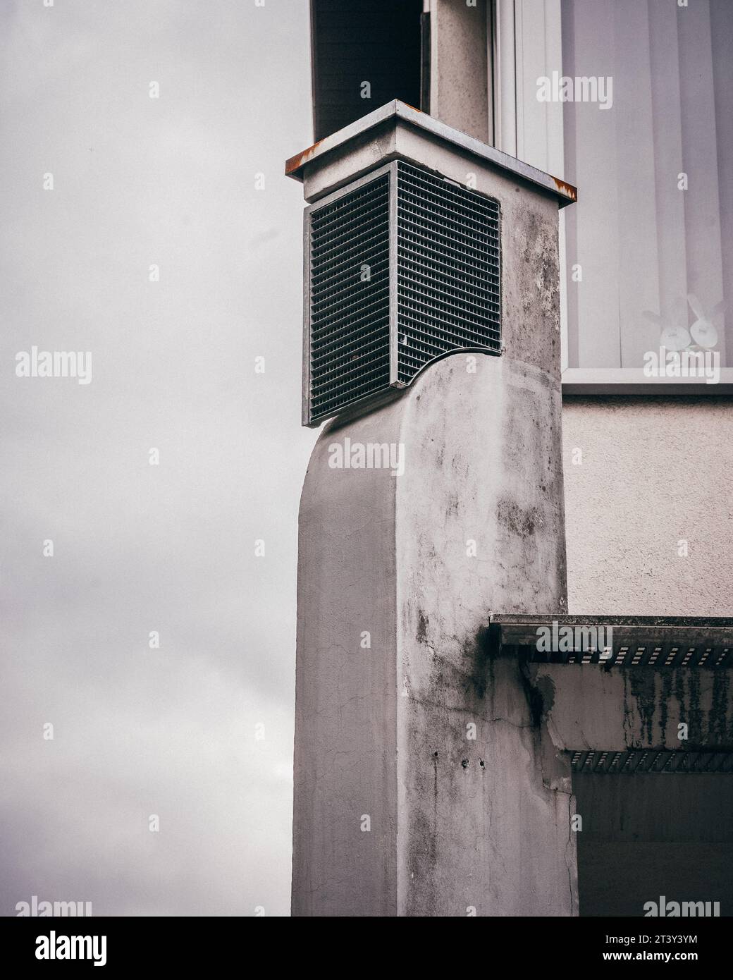 An old air conditioner unit mounted on the outside wall of a ...