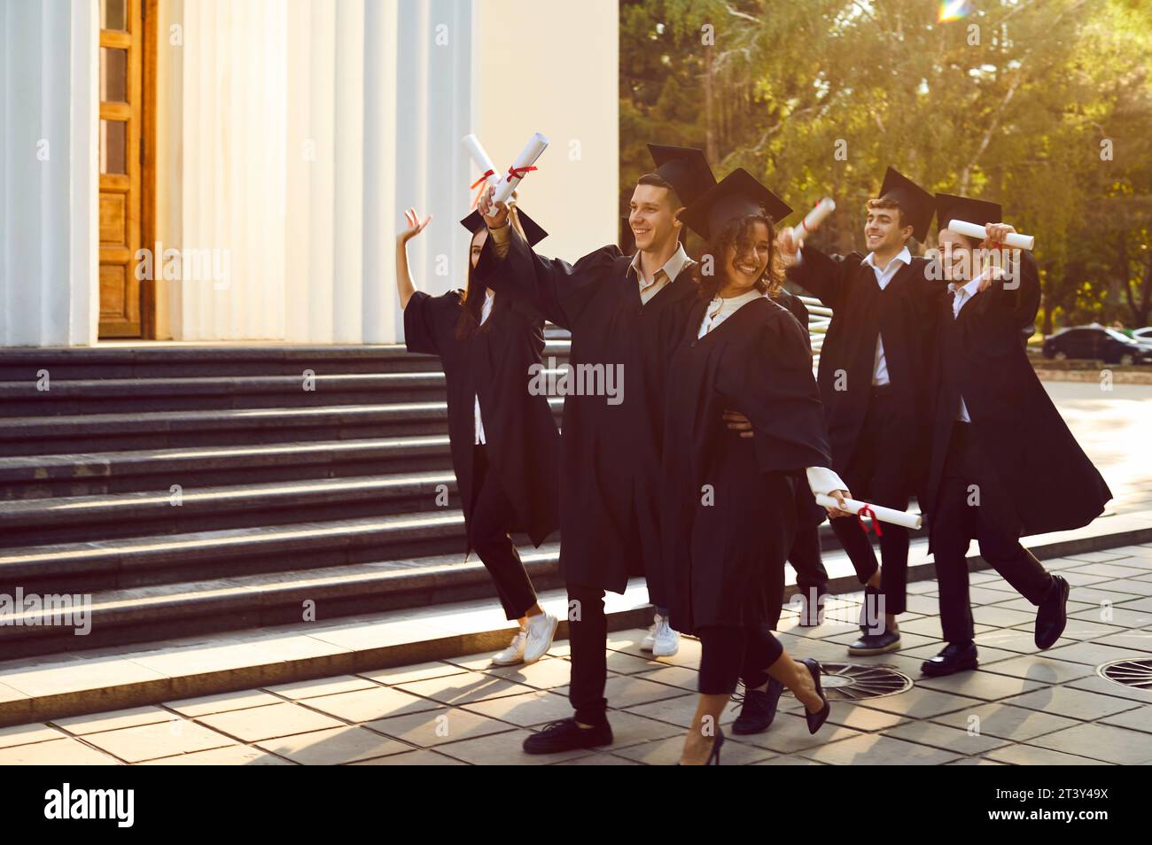 Happy smiling graduates students classmates walking in black graduate ...