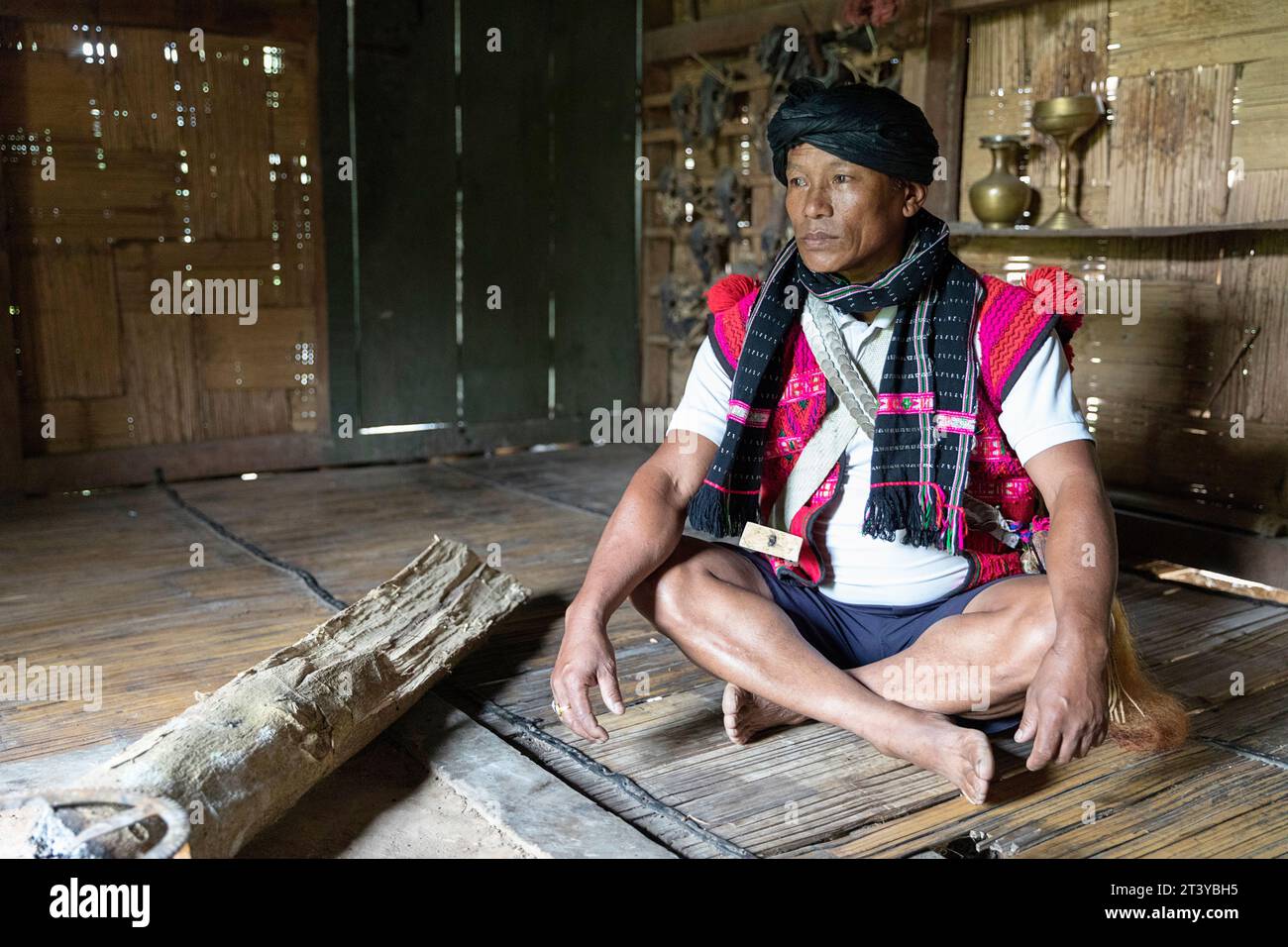 Man from Adi tribe in traditional clothes sitting by the fireplace in ...