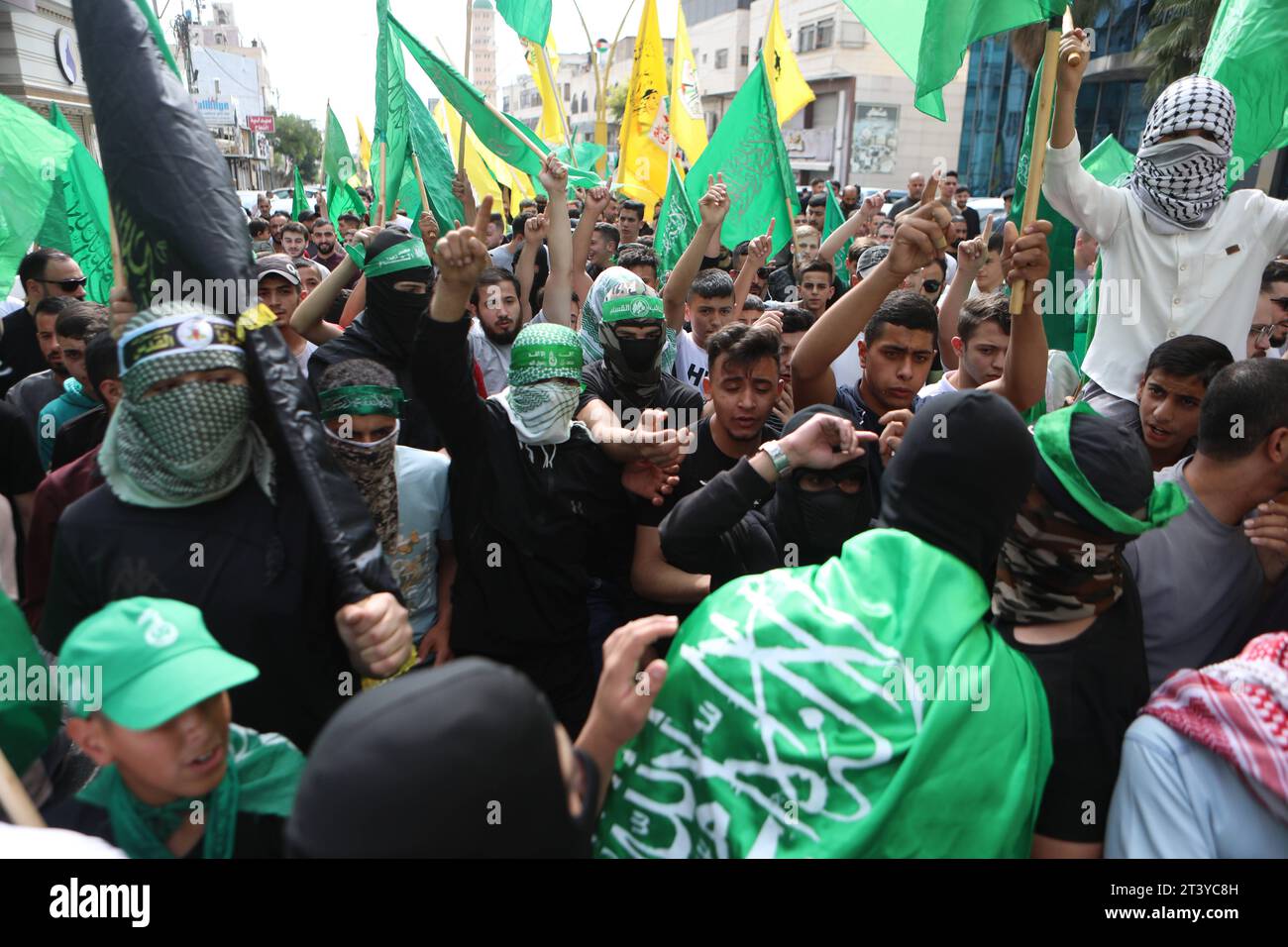 Palestinians waves Hamas and Fateh flags as they takes part in a march ...