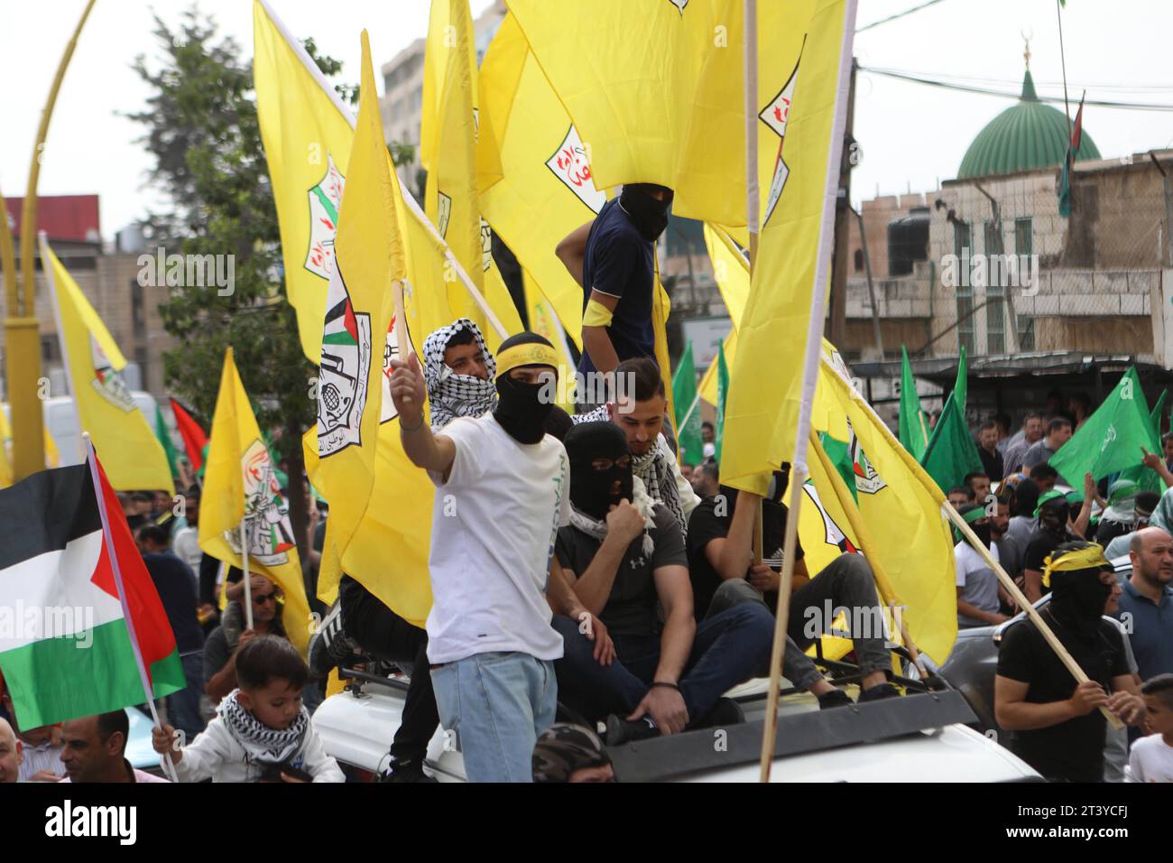 Palestinians waves Hamas and Fateh flags as they takes part in a march ...