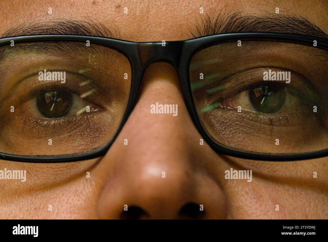 partially blurred click of a pair of human eyes front view with specs ...