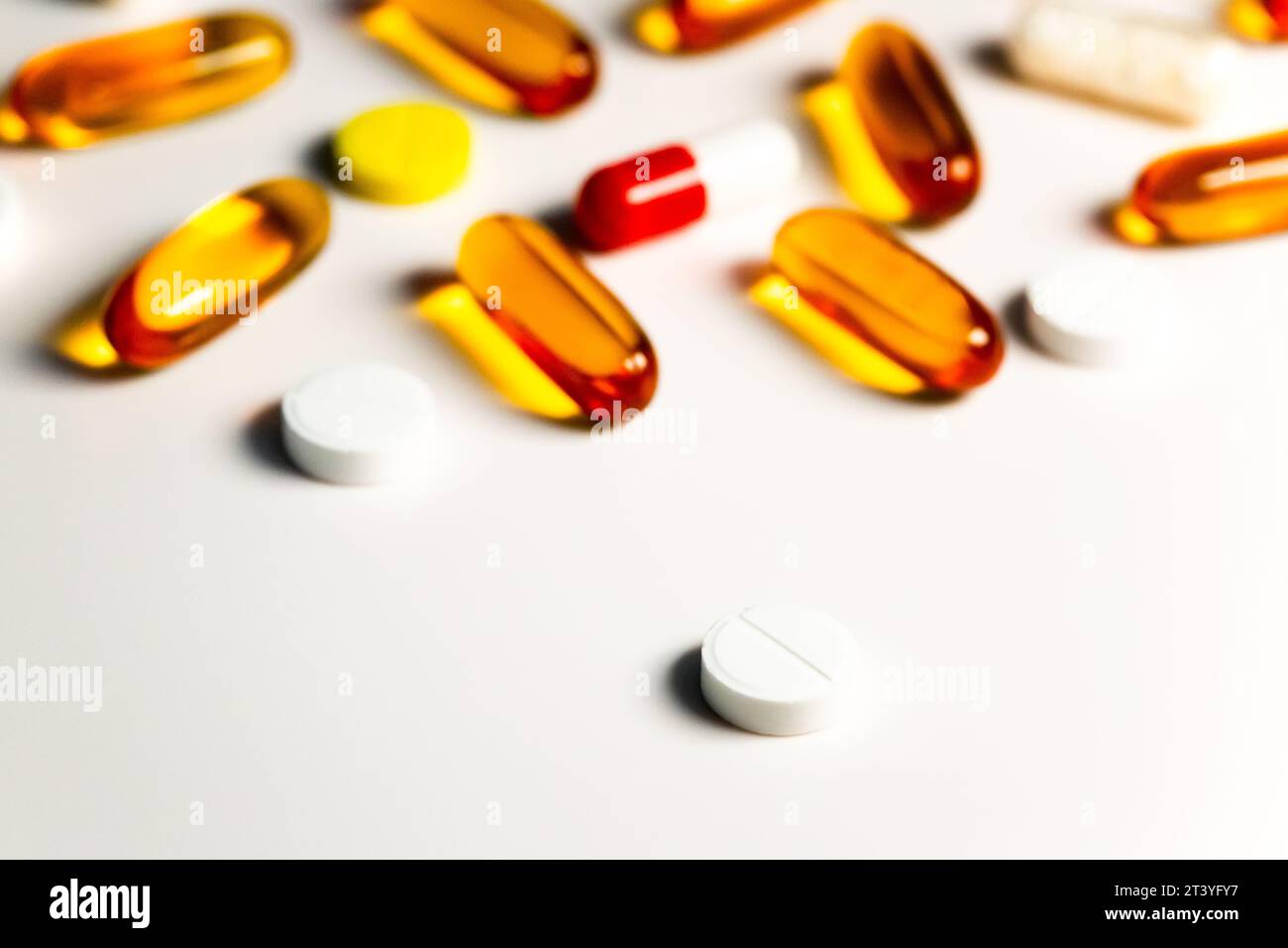 One white universal tablet on a background of scattered multicolored ...