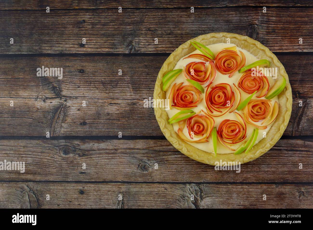 The top view of the apple pie rose shape on rustic wooden background ...