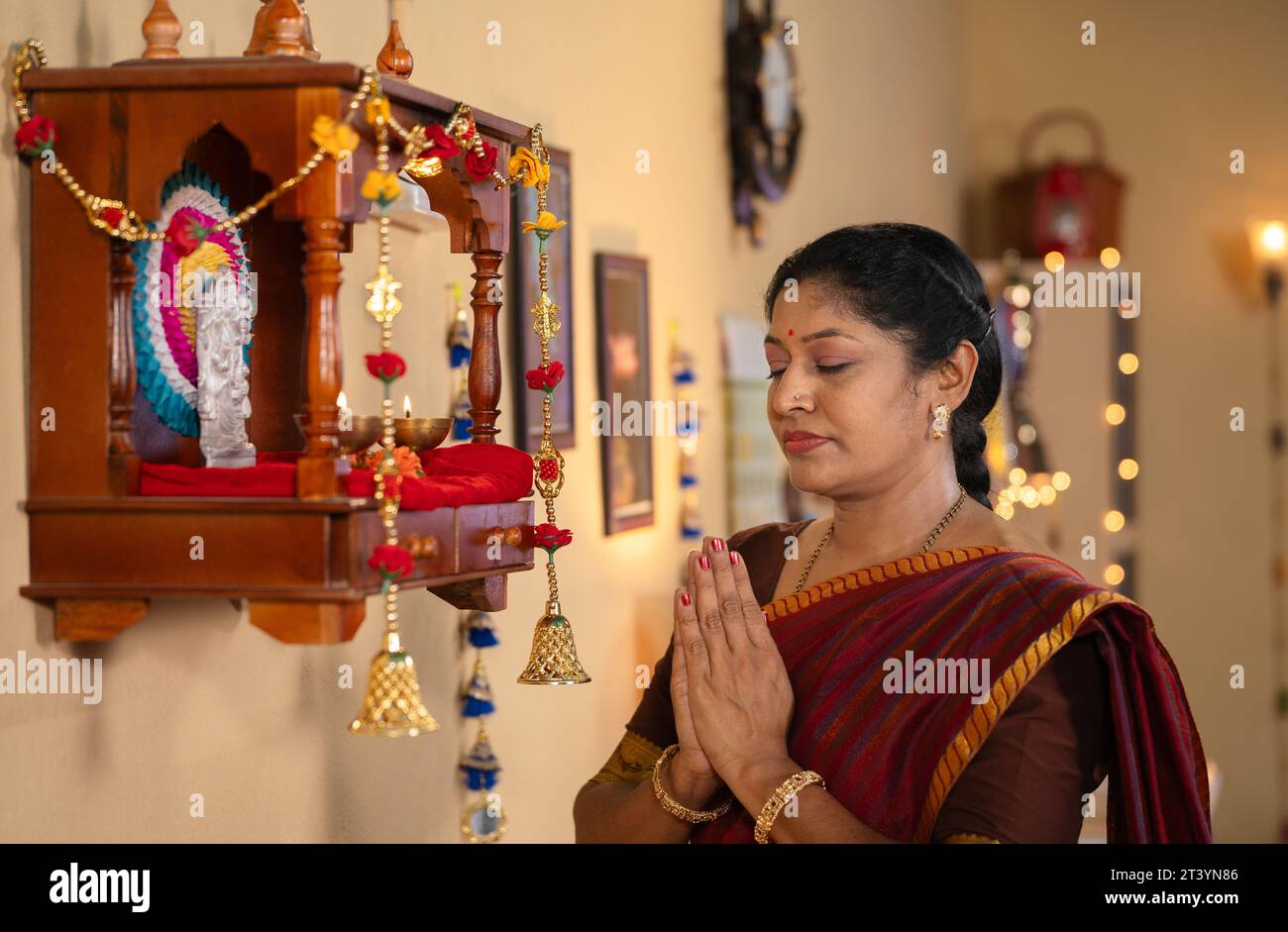 devotional Indian woman praying to god by folding hands in front of ...