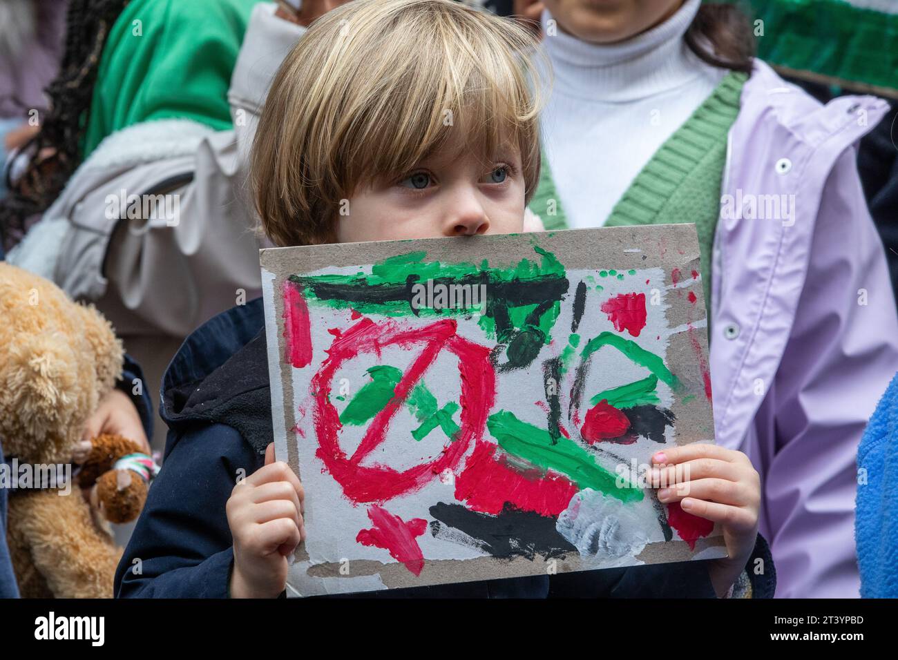 London, UK. 27th October, 2023. A child holds a hand-painted sign at a ...