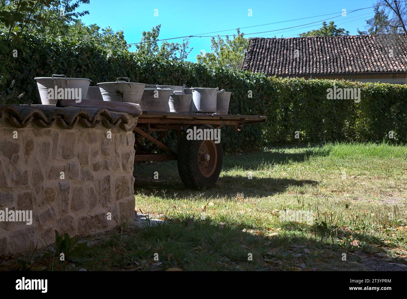 Tin buckets on a carriage in a garden Stock Photo - Alamy