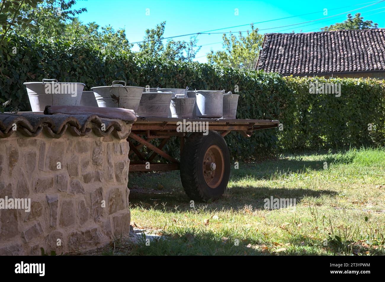 Tin buckets on a carriage in a garden Stock Photo - Alamy