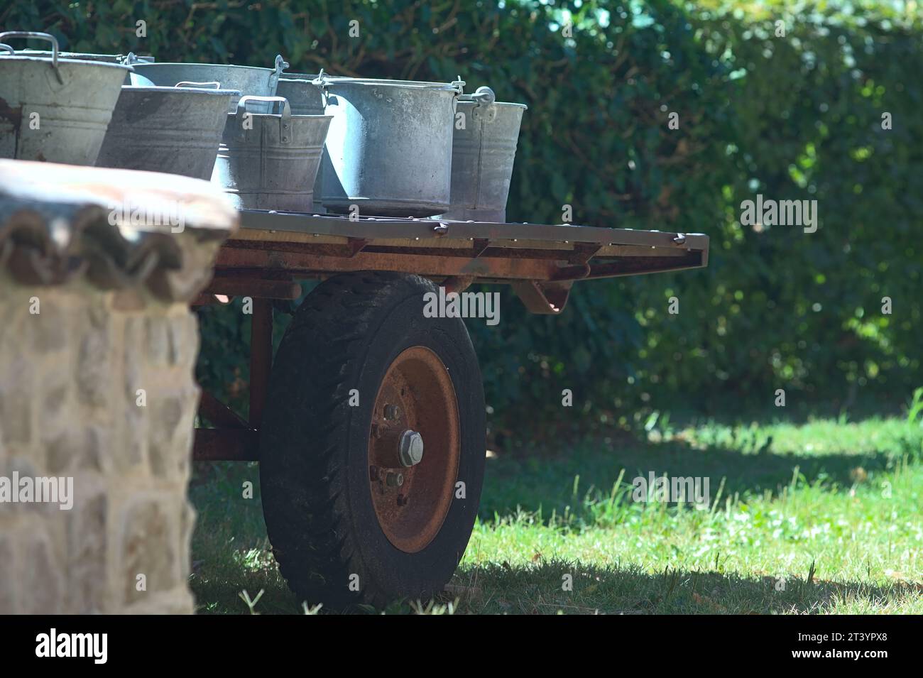 Tin buckets on a carriage in a garden Stock Photo - Alamy