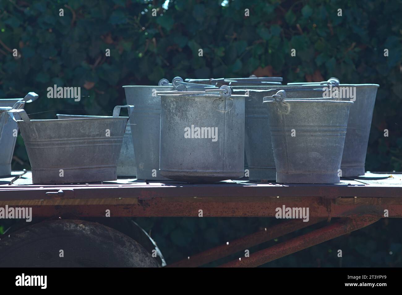 Tin buckets on a carriage in a garden Stock Photo - Alamy