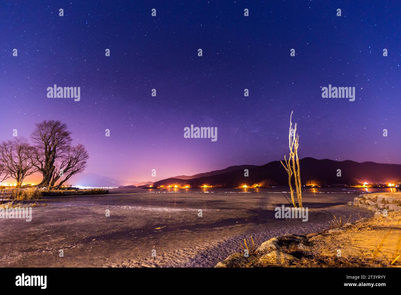Frozen lake in South Korea in winter at night and sky filled with stars ...