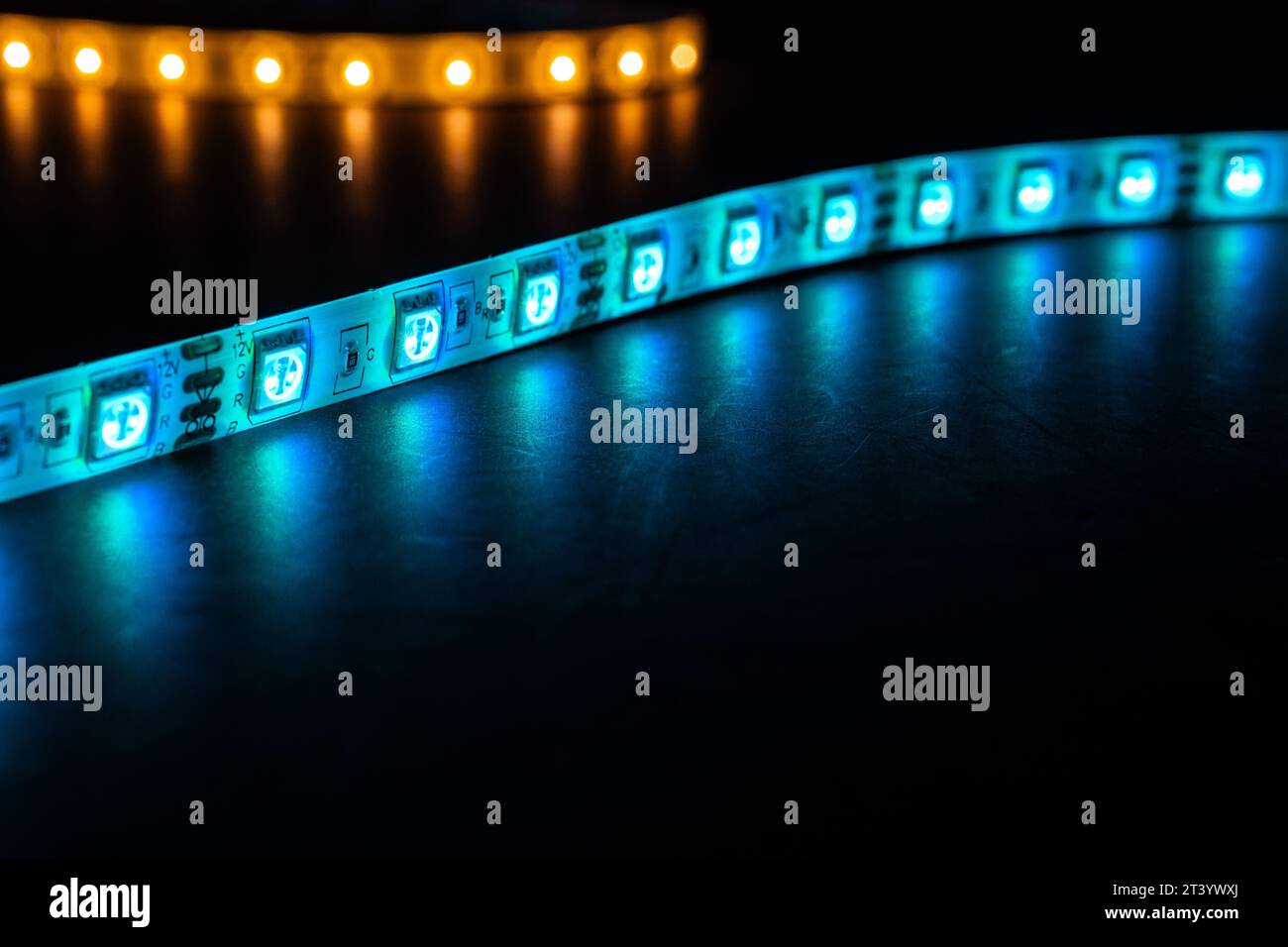 Bobbin with roll of glowing LED strip lighting placed on table, pink ...