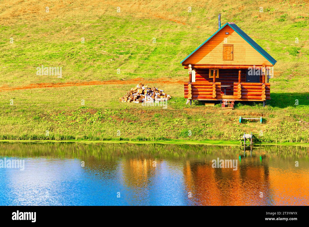 wooden house on the shore of a pond. wooden log house on the lake shore ...