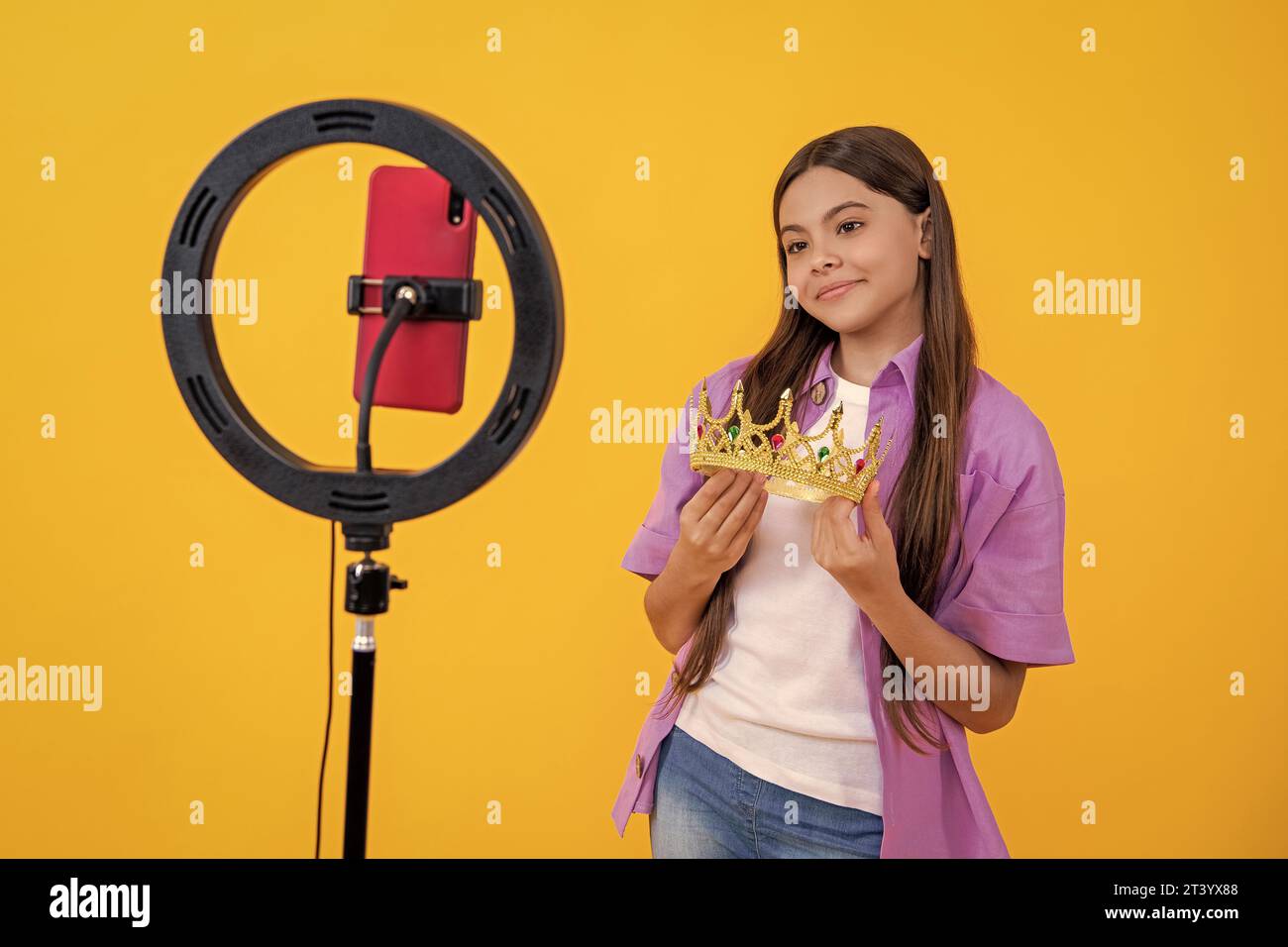 cheerful teen girl influencer with crown in studio. teen girl influencer with crown on ...